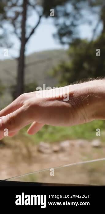 Vertical video. A Hand Reaching Out the Window of a Car, Feeling the ...
