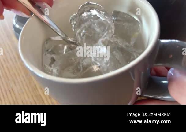 sparkling water glass falling ice cube. slow motion falls ice in cold mineral water. soda water ...