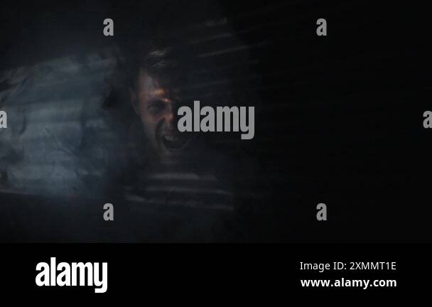 A mans face partially illuminated by horizontal light strips, casting ...