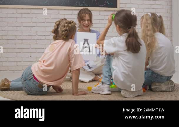 Group of kids visiting preschool classes. Young woman teacher and group ...
