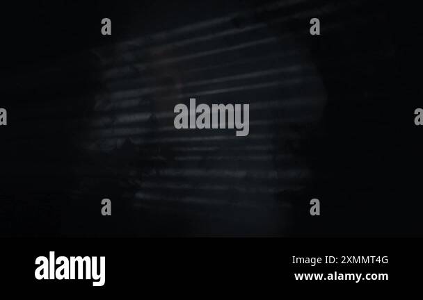 A mans face partially illuminated by horizontal light strips, casting ...