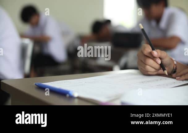 Close up hand of student reading and writing exam answer sheets ...