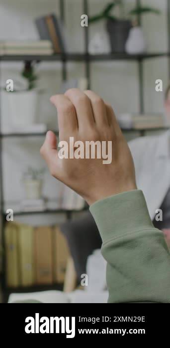 Close-up vertical shot of hand of unrecognizable young man repeating ...
