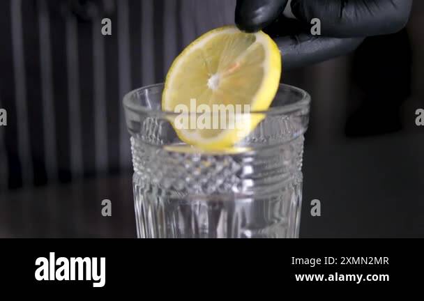 Add lemon to glass. Making lemonade, summer drink, cold drink, healthy ...