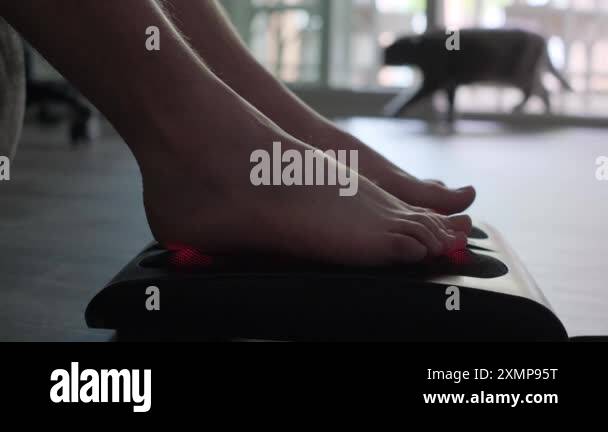 A person uses a foot massager to relax their feet and later stands on a ...