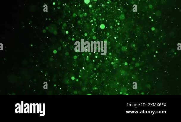 Small green particles spread in the dark, creating a dynamic and ...