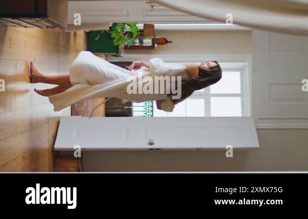 Dancing lady moving slowly at beige apartment vertically oriented. Lazy ...