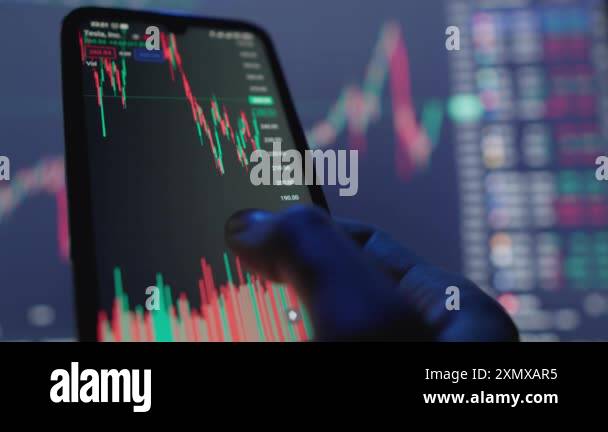 Dynamic footage shows a smartphone displaying stock market charts, with ...