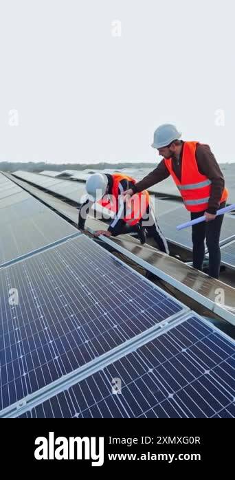 Solar panels installation. Two workers in a uniform and hard hat ...