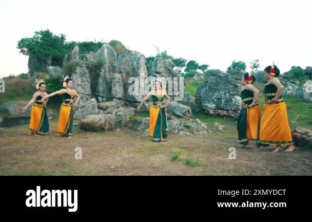 A group of dancers in traditional attire performing in a natural ...