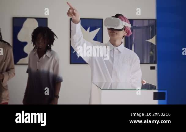 Young Asian man with pink hair tapping and swiping on invisible touch ...