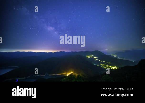 The Milky Way stretches in the starry night sky above the sea of clouds ...