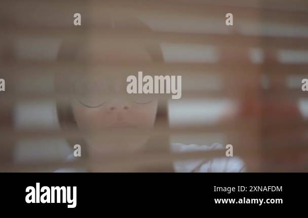 Close-up. A beautiful woman in glasses slides the horizontal slats on ...