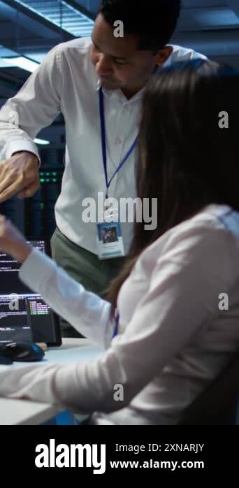 Vertical video Engineering team colleagues in data center managing gear ...