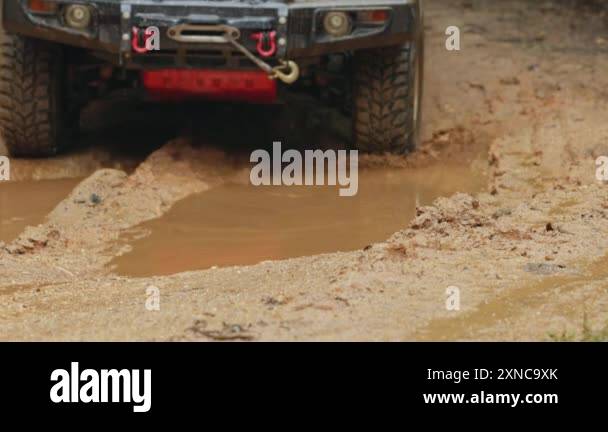 Cars running on off-road roads and splashing mud on natural paths. Off-road travel on muddy road ...