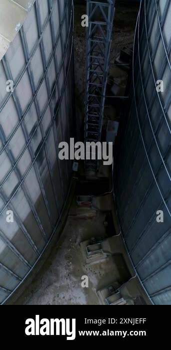 Going down among two huge metal granary tanks. Exterior footage of the ...
