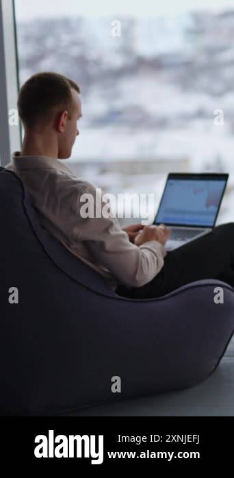 Working man sits with his back to the camera typing on his laptop. Male ...
