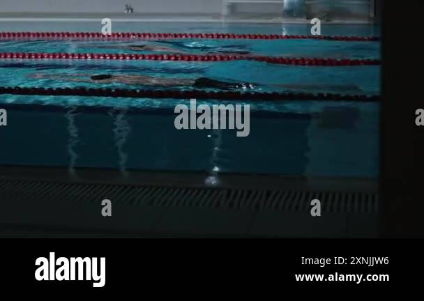 Two professional male swimmers practicing race swimming in lane pool ...