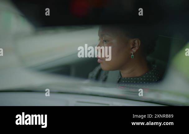 A woman is captured driving her car while appearing deep in thought or ...