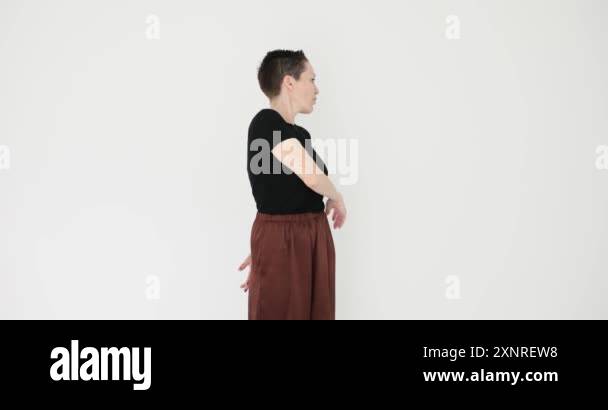 Woman engages in warming up activity moving arms on white background ...
