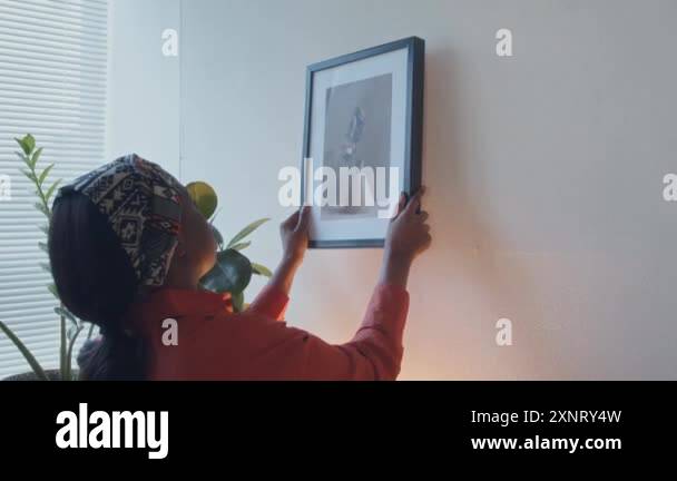 Woman hanging frame Stock Videos & Footage - HD and 4K Video Clips - Alamy