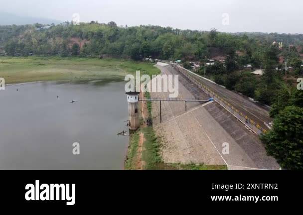 Aerial view of a dam with a large reservoir and surrounding greenery ...