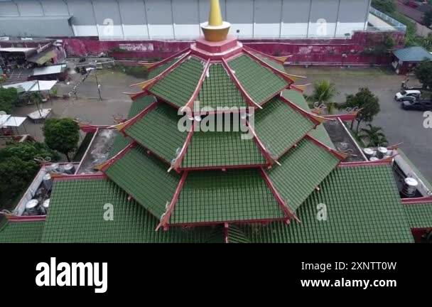A traditional Asian-style building with green tiled roofs and red ...