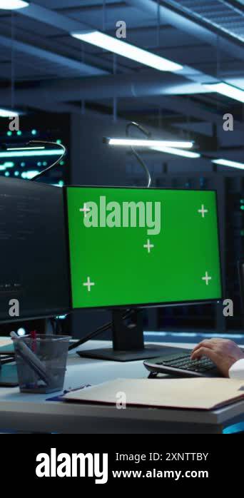 Vertical video Engineer working with chroma key PC in data center used ...