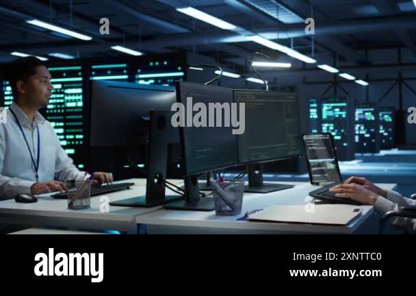 System administrator in wheelchair overseeing data center using computer, ensuring system can ...