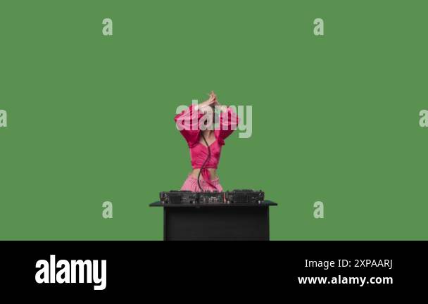 Dynamic video of a female DJ at the console mixing tracks and dancing ...