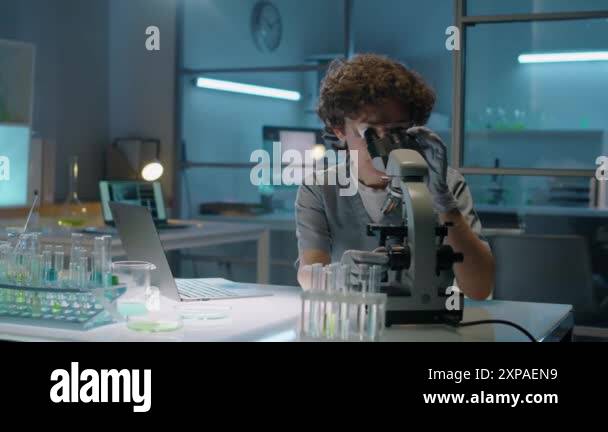 Medium tilt shot of young Caucasian female biochemist in uniform ...