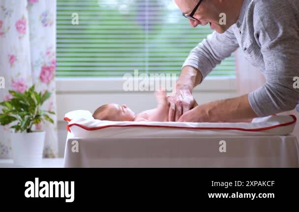 Middle age father changing diaper for newborn baby. Male parent taking ...