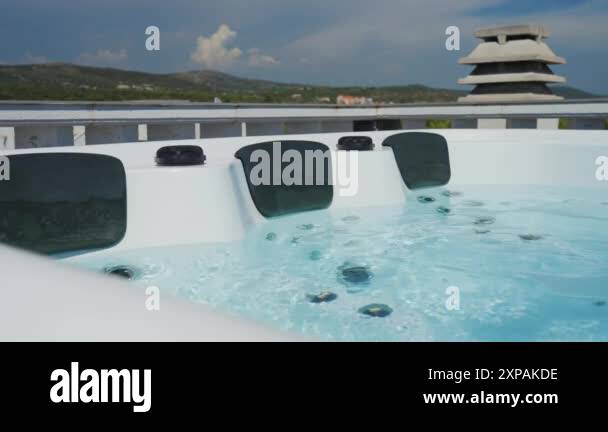 Close-up shot bubbling water in hot tub with headrests. Blue water in ...
