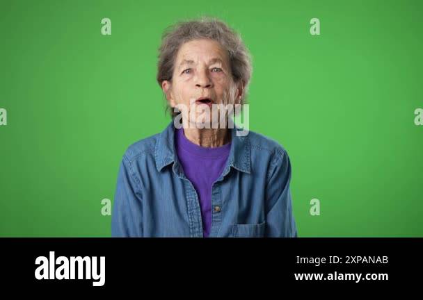 Portrait of elderly senior old woman look camera laugh smiling watch comedy movie pointing index ...