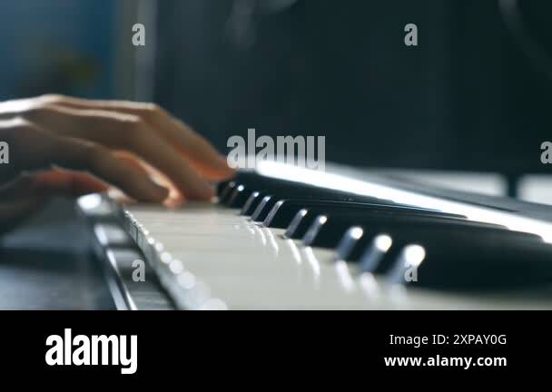 Close up fingers of pianist at the piano keys. Mens arms plays solo of ...