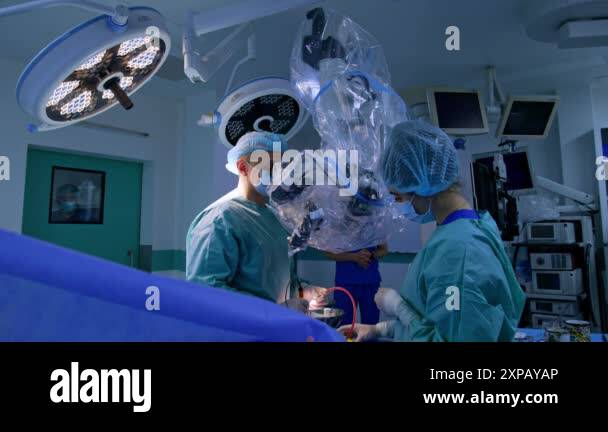 Professional neurosurgeon comes up to a microscope. Doctor holds ...