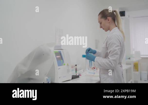 Female laboratory technician using hematology blood analyzer. Medical ...