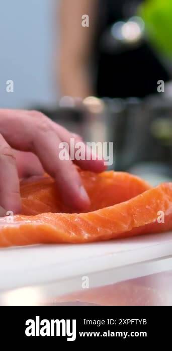 male chef hand using fish fillet knife slice fresh salmon meat on ...