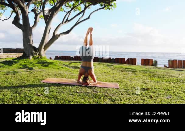 In the peaceful outdoors, a woman demonstrates strength and balance ...
