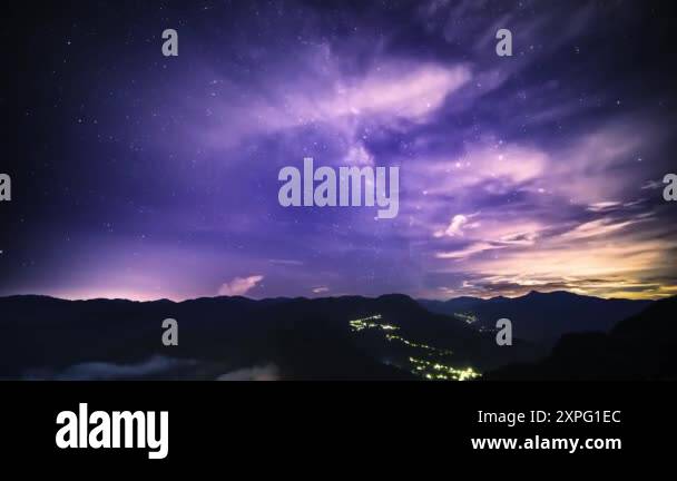 The Milky Way stretches in the starry night sky above the sea of clouds ...