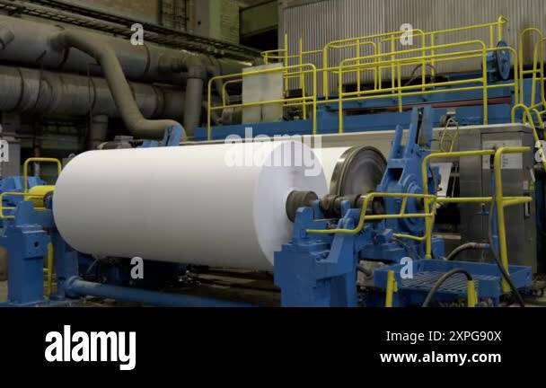 Huge paper material roll coiled by rotating drum in manufacturing ...