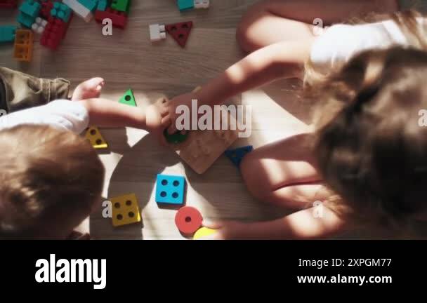 Top view of little children building tower of wooden block toys. Kids ...