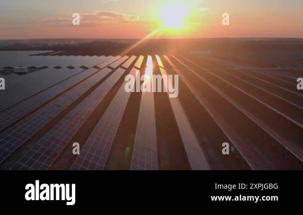 Aerial drone view into large solar panels at a solar farm at cloudy ...