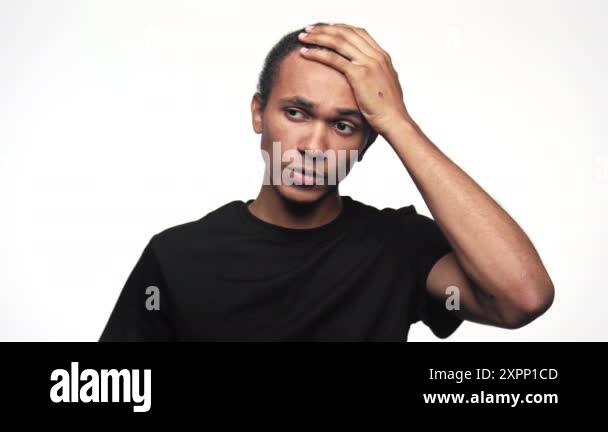 Concerned man in a black shirt touching his head in trouble on a plain ...