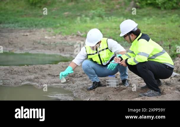 Environmental engineers work at water source to check for contaminants ...