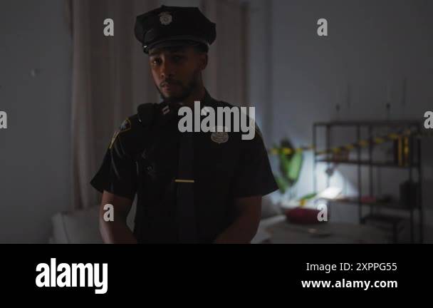 African american police officer in uniform standing solemnly in a dimly ...