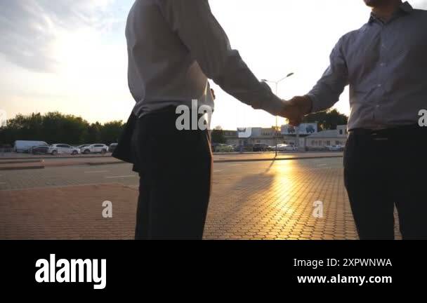 Two businessmen meeting at city street and greeting each other ...