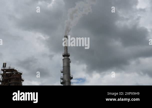 Working gas flare or flare stack with clouds of exhaust fumes under ...