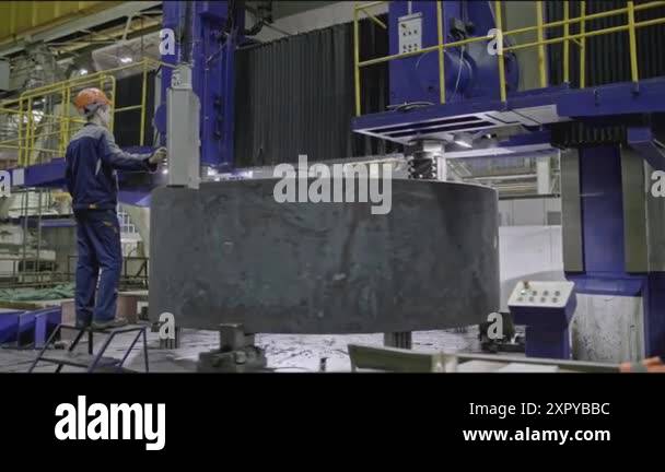 Worker with automated grinding at factory. Stock clip. Worker with ...
