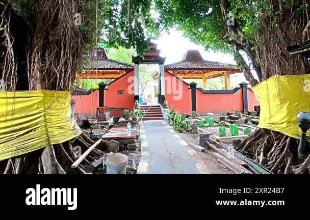 A serene view of a traditional Balinese temple framed by lush green ...